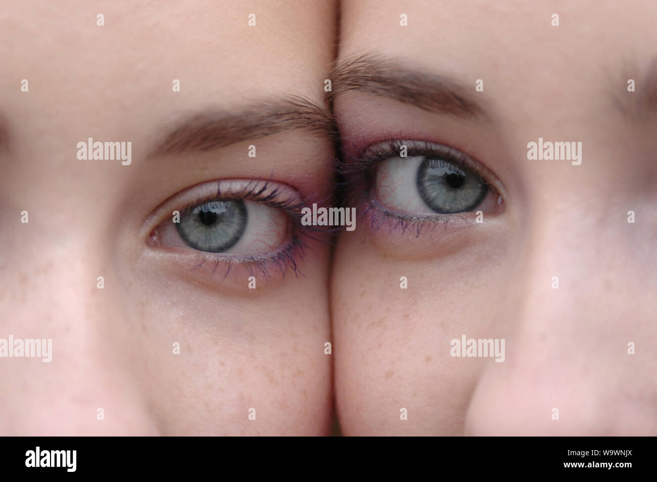 Two young girl face cheek to cheek looking at camera Stock Photo - Alamy