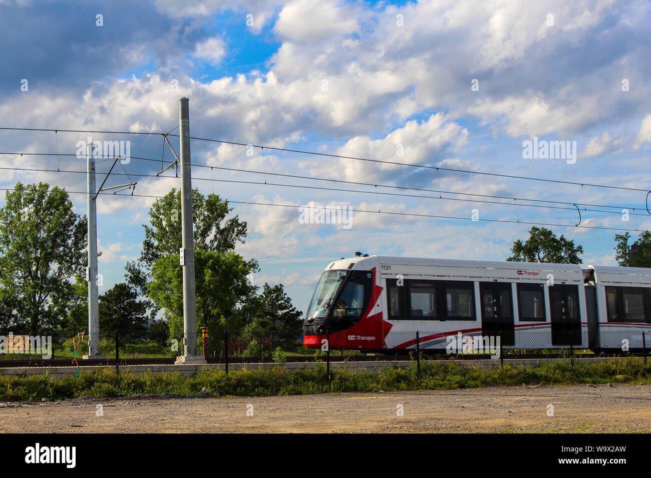 One of OC Transpo's new light rail trains proceeds along the track by ...