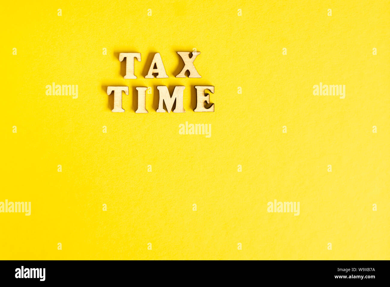 Economic phrase Tax Time isolated on yellow paper background with copy ...