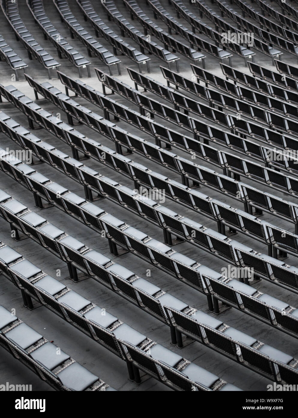 Grey and white circular rows of empty concert seats in an opera house ...
