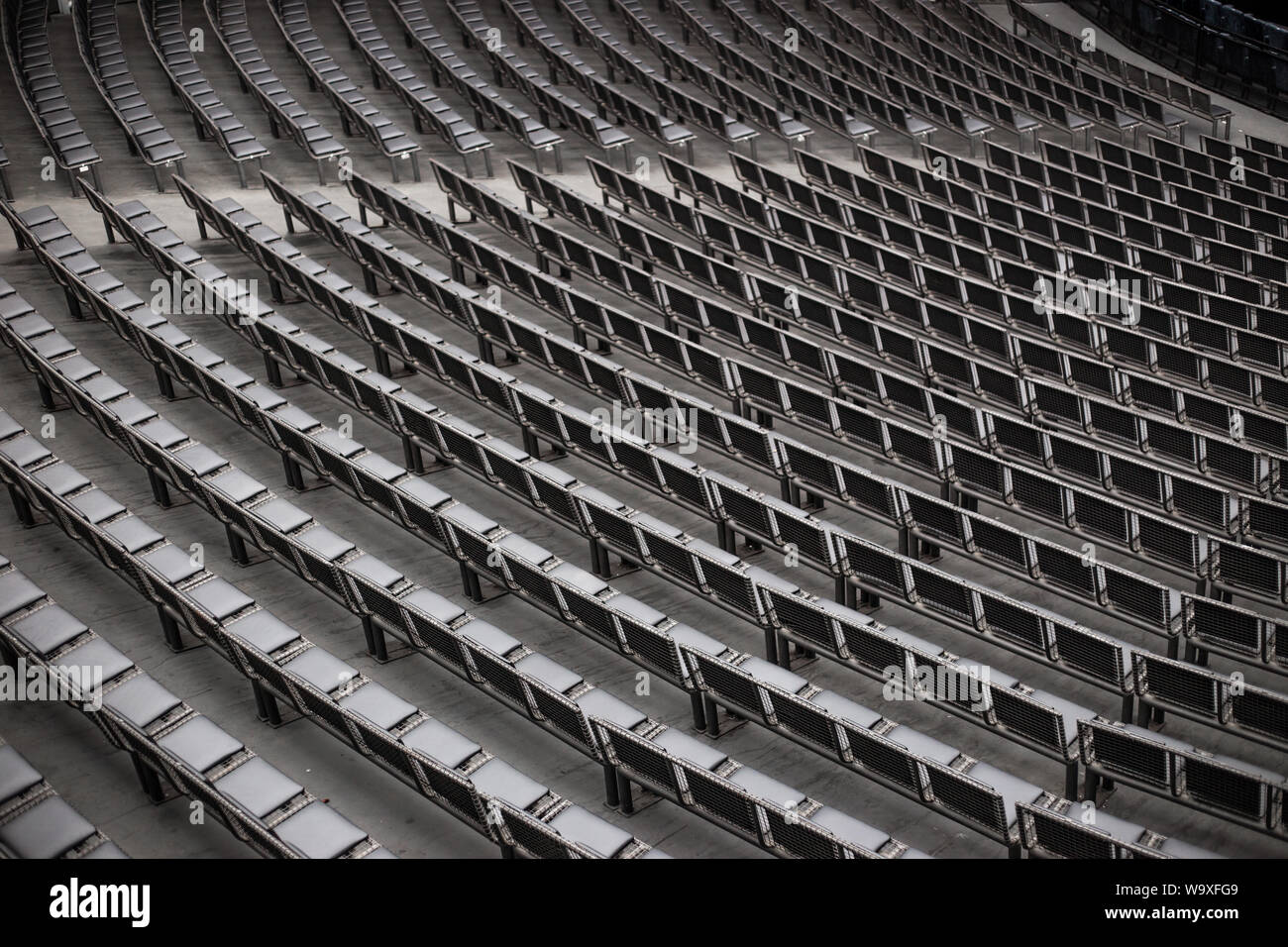 Grey and white circular rows of empty concert seats in an opera house ...