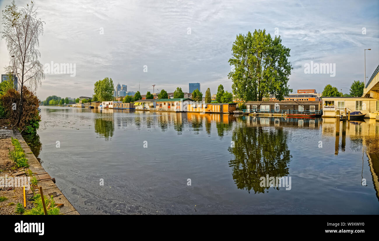 Amsterdam floating houses in river Amstel channel Stock Photo - Alamy