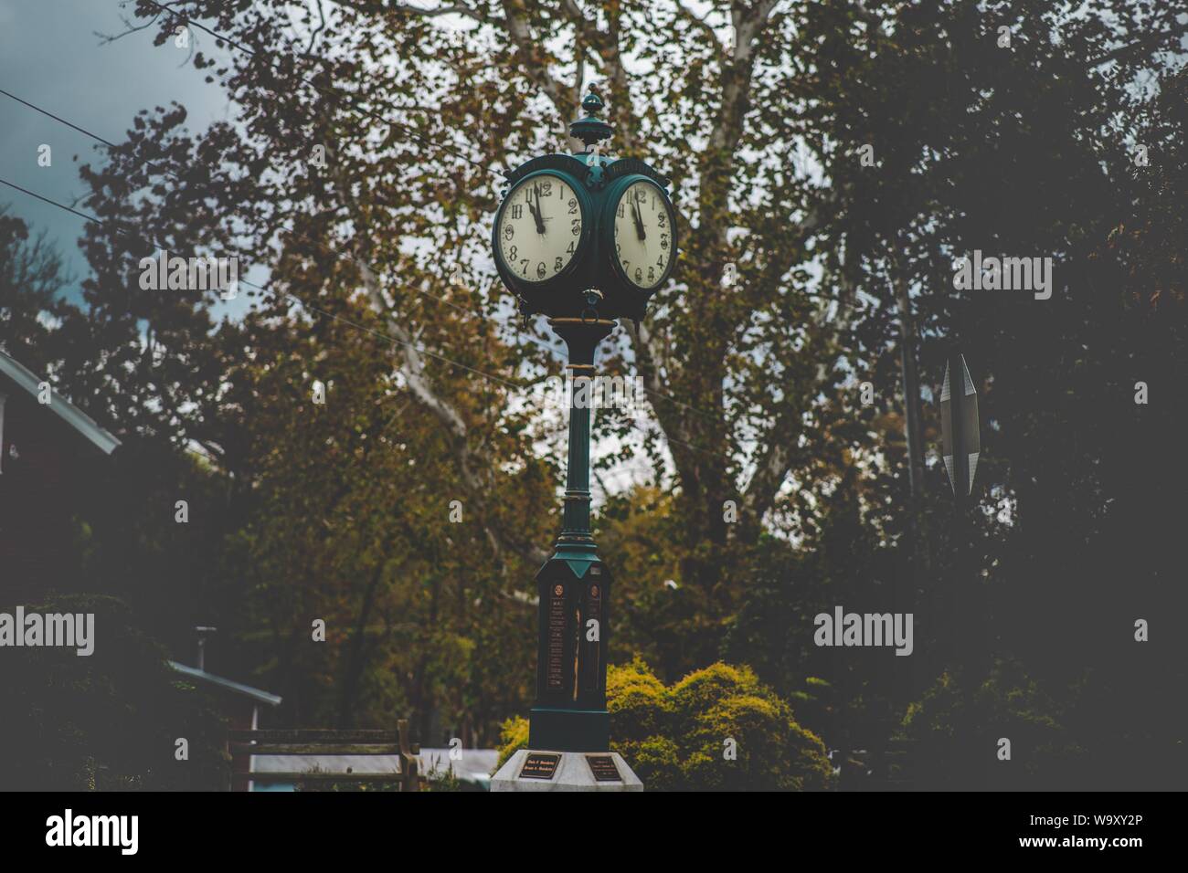 Shot of a green analog clock tower in the street Stock Photo - Alamy
