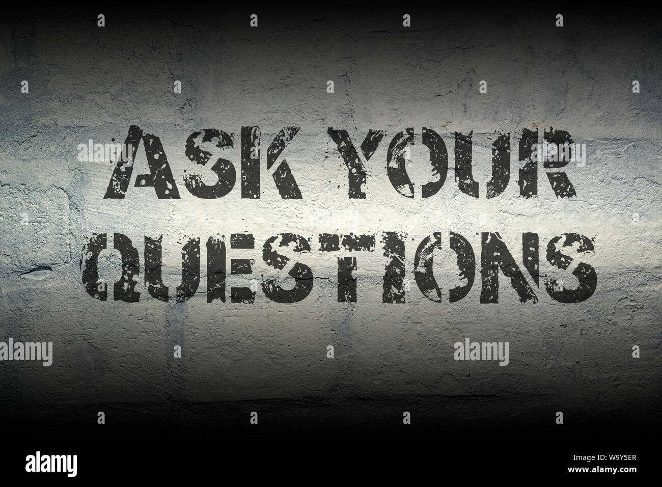 ask your questions stencil print on the grunge white brick wall ...