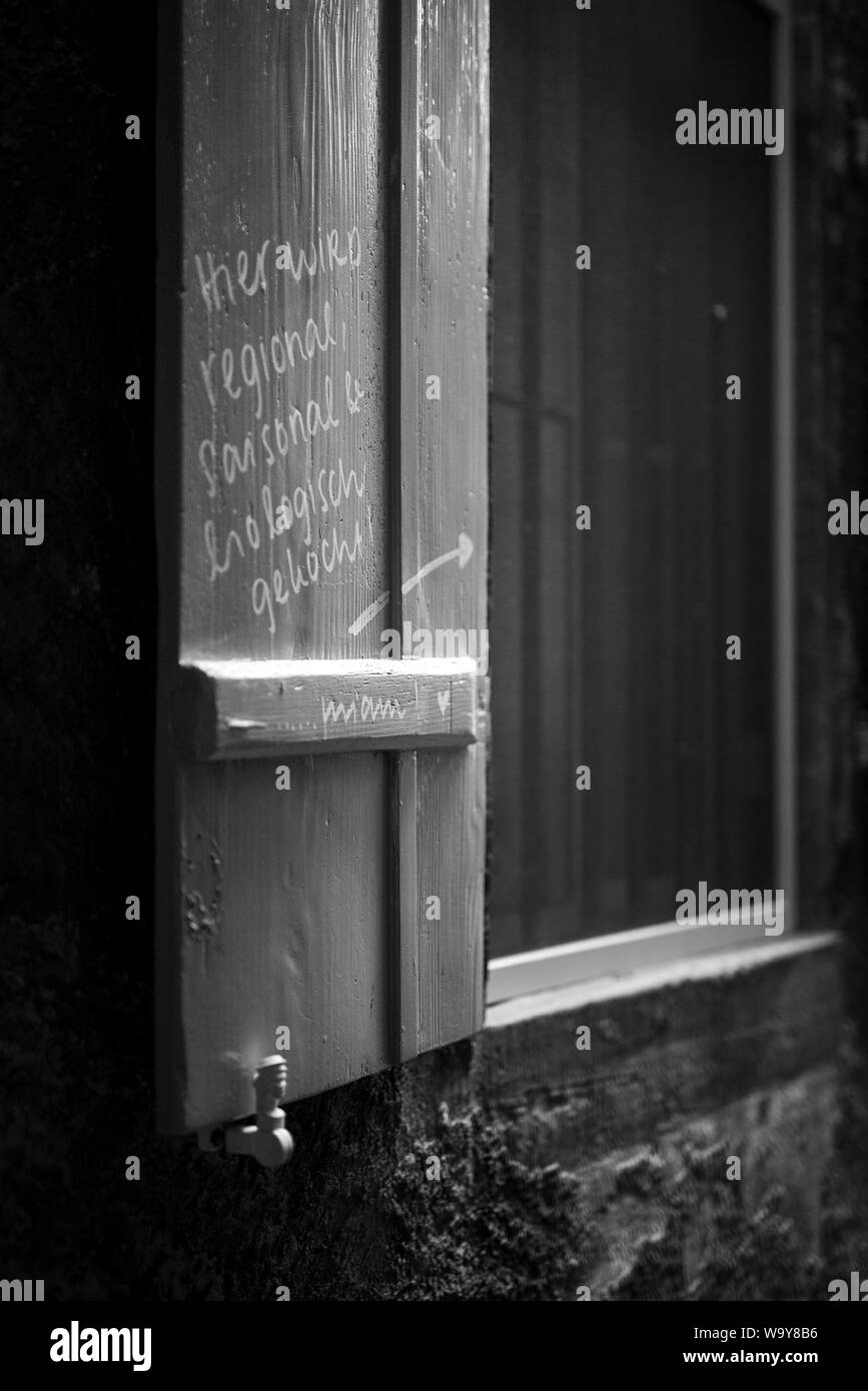 Grayscale vertical closeup shot of words written on a wooden window ...