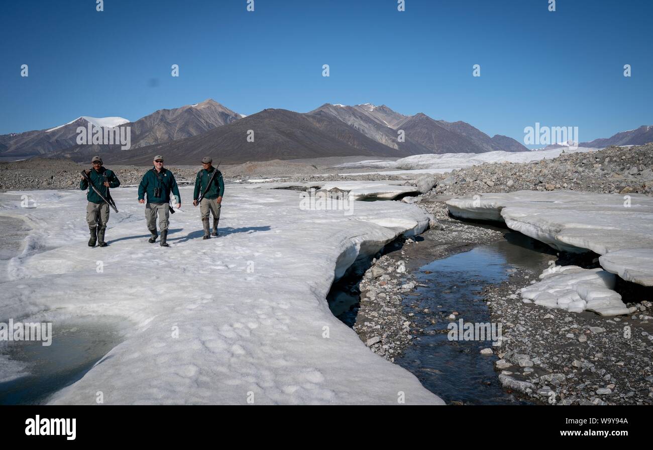 Pond Inlet, Canada. 15th Aug, 2019. Armed park rangers walk over a ...