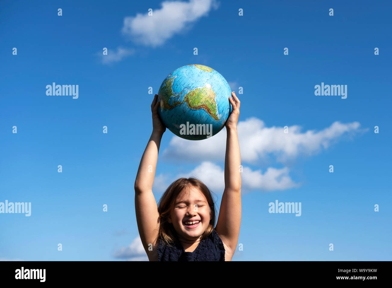 Smiling girl holding planet Earth. Happy child with globe in raised ...