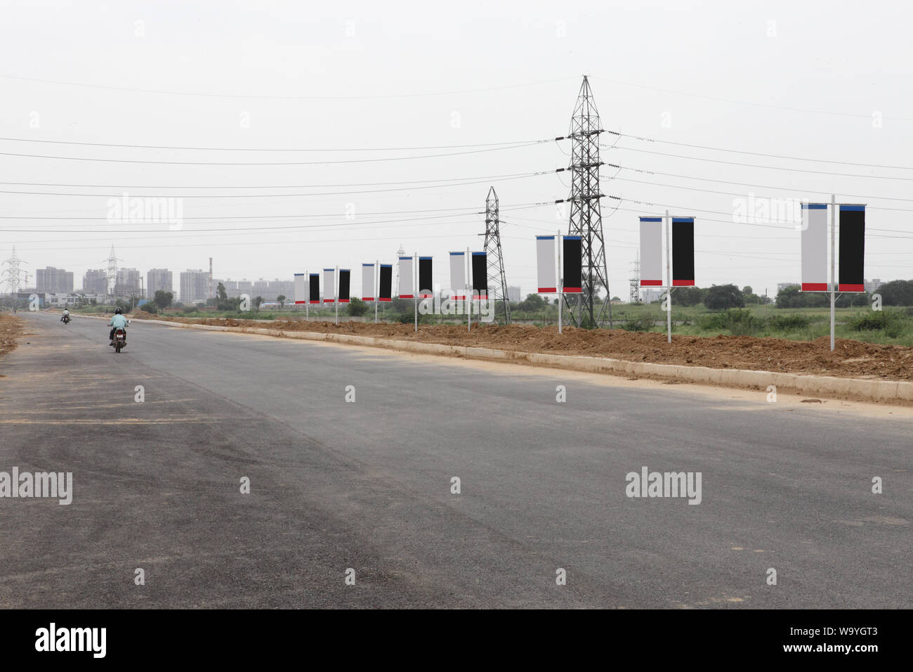 Electricity pylons passing through on the road Stock Photo - Alamy