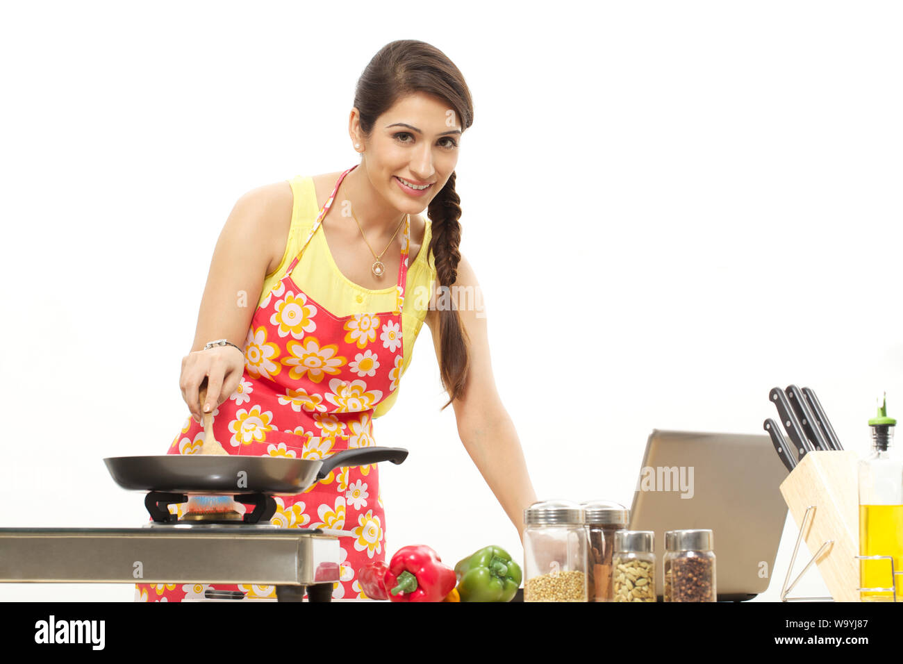 Young woman cooking food in frying pan Stock Photo - Alamy