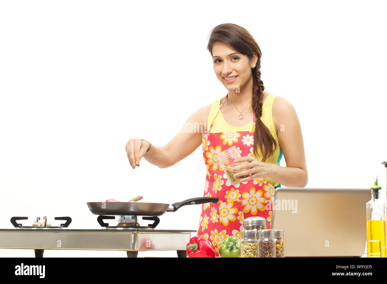 Young woman cooking food in frying pan Stock Photo - Alamy