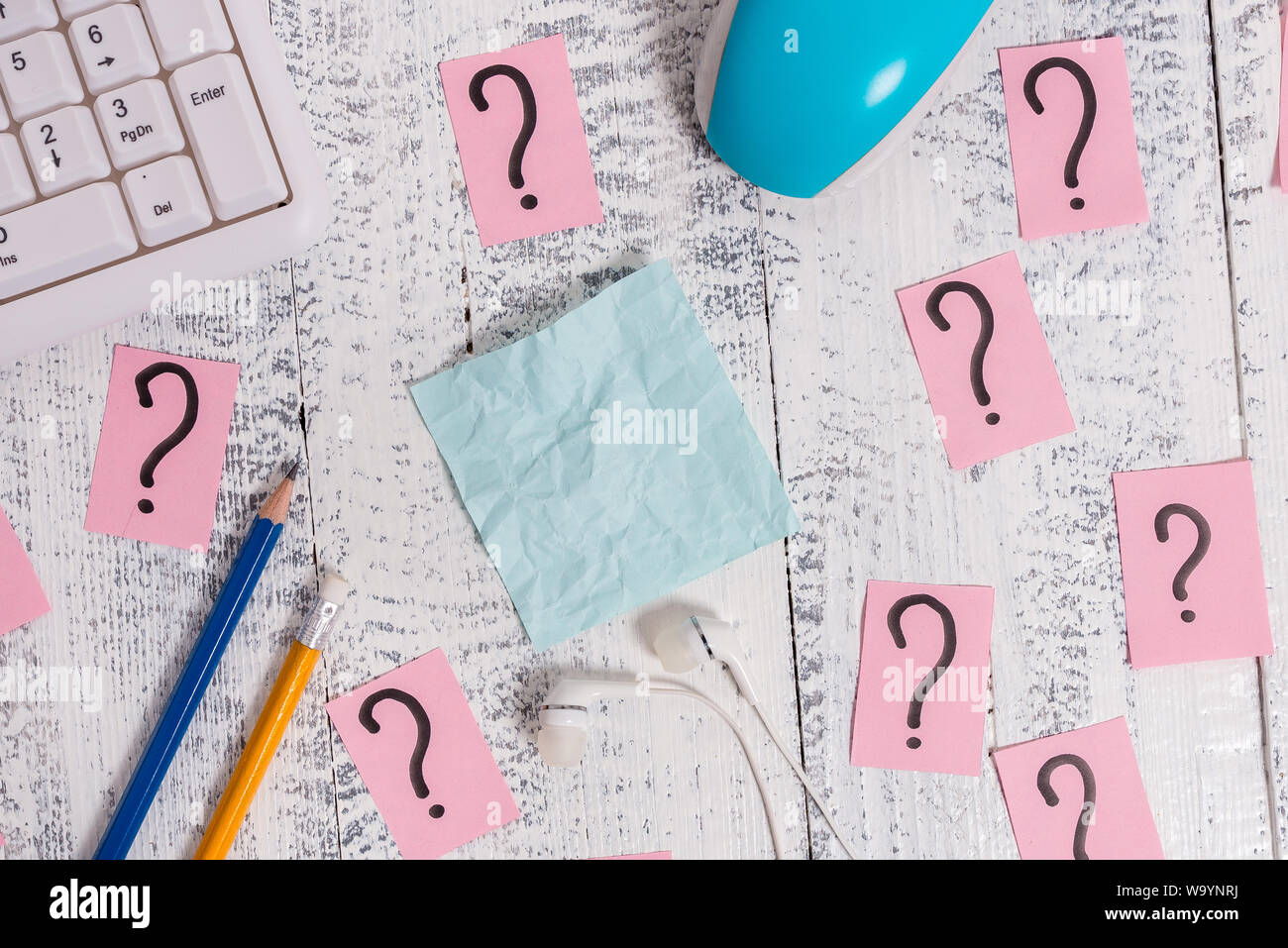 Writing tools, computer stuff and scribbled paper on top of wooden ...