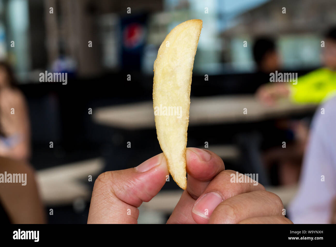 French fries the handle by fingers in the restaurant Stock Photo - Alamy