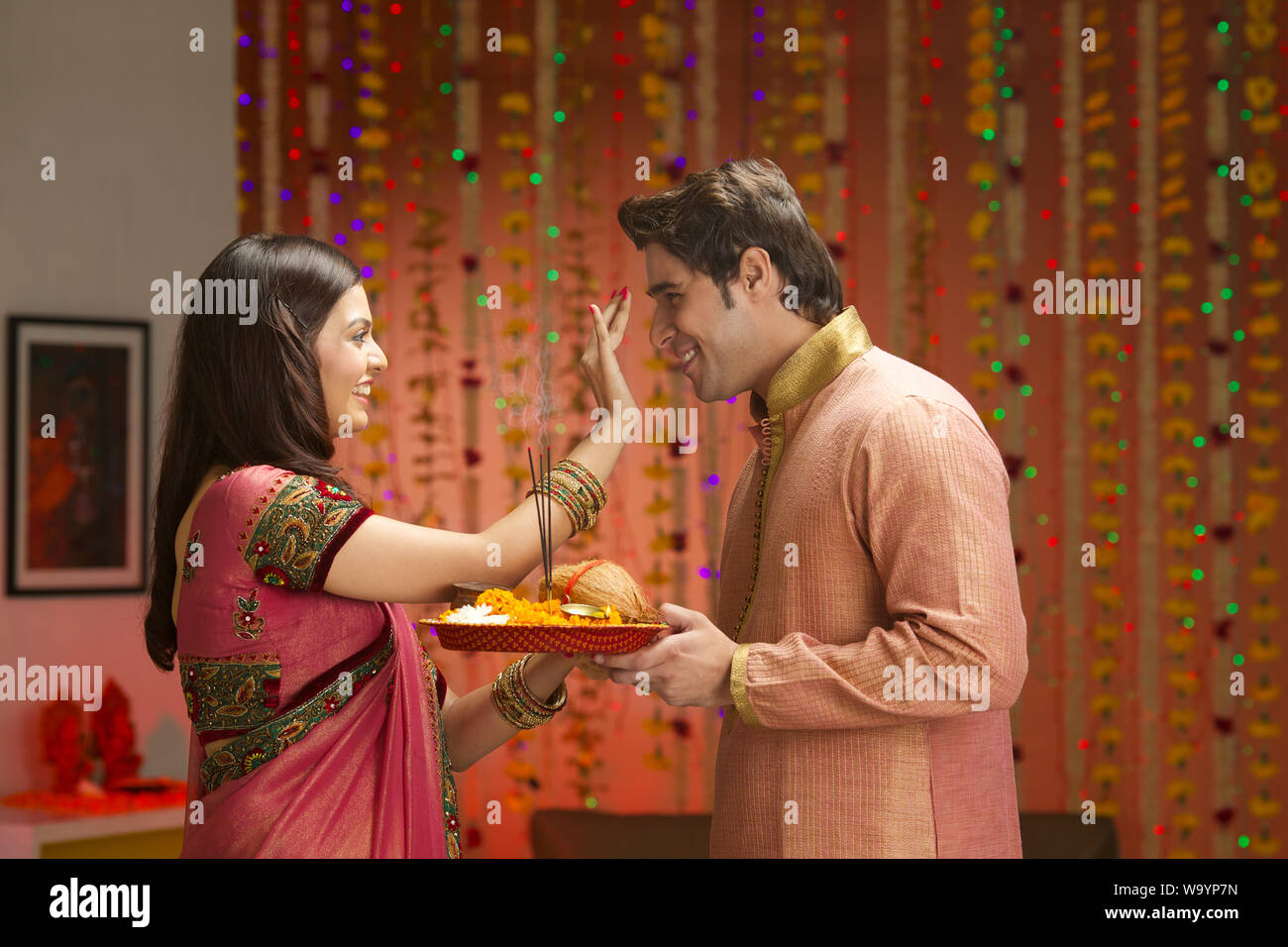 Young woman applying tika on her husband forehead Stock Photo - Alamy