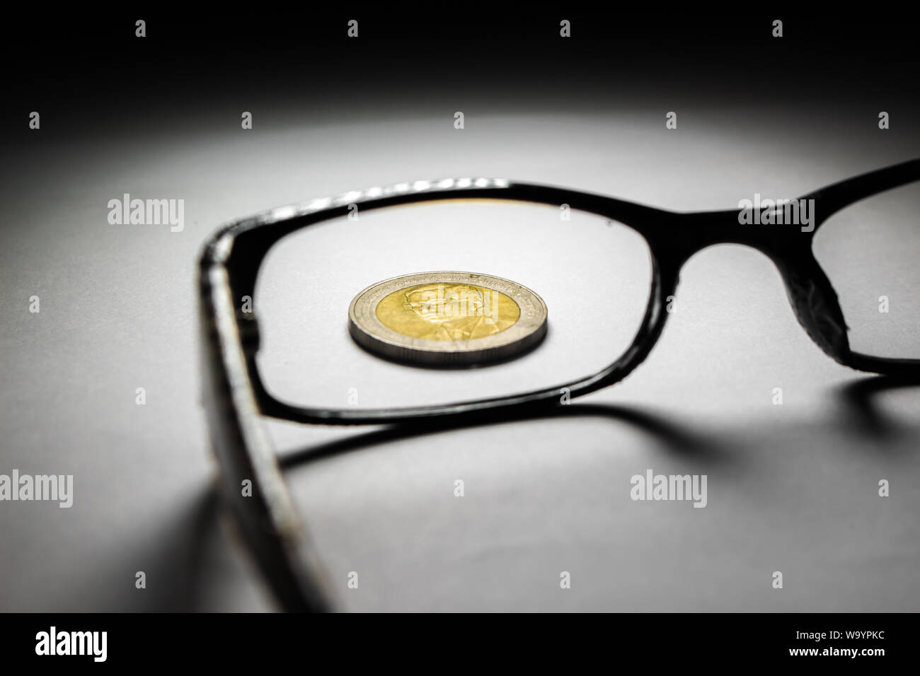 Stack of coins with the king on the coin to look through the glasses ...