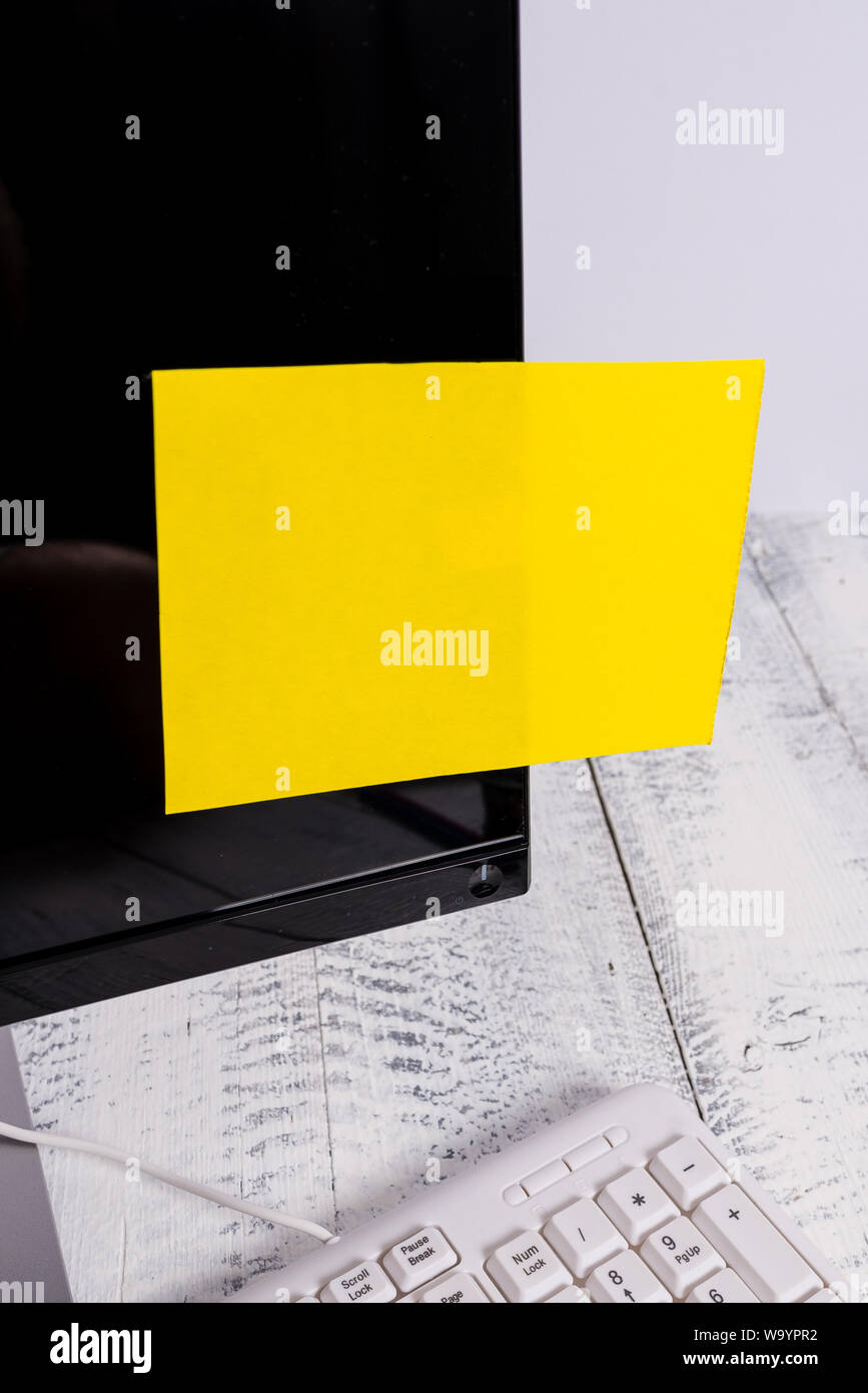 Notation paper taped to black computer monitor screen near white ...