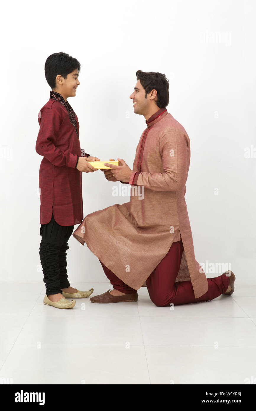 Boy giving gift to his father and smiling Stock Photo - Alamy