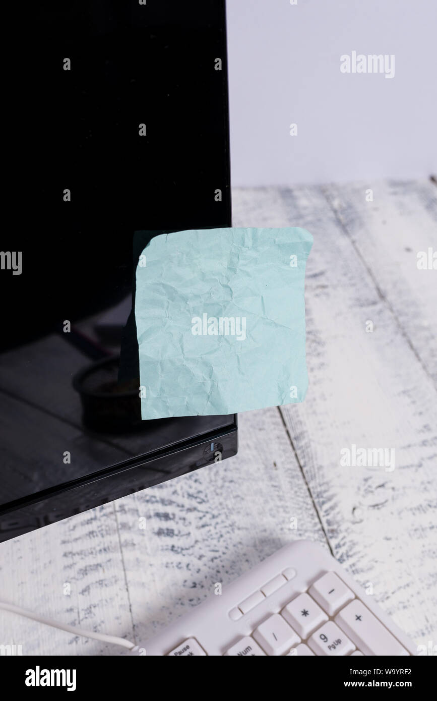 Notation paper taped to black computer monitor screen near white ...