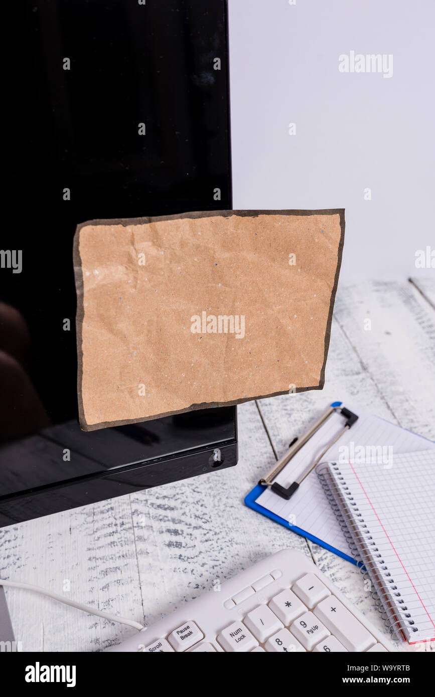 Note paper taped to black computer screen near keyboard and stationary ...