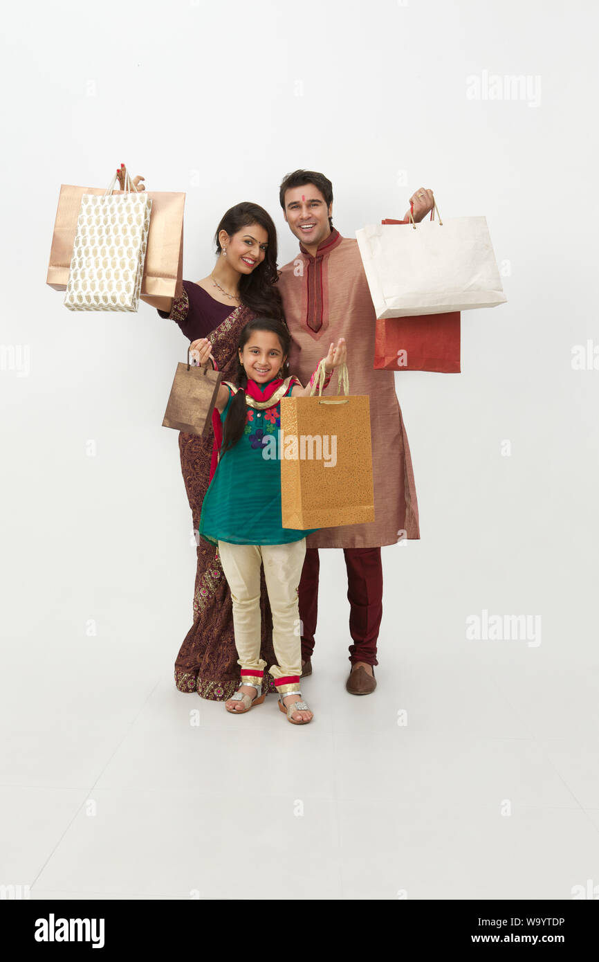 Family carrying shopping bags and smiling Stock Photo - Alamy