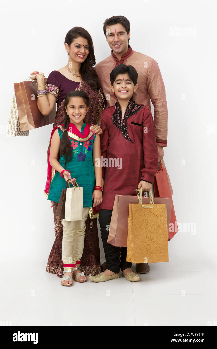 Family carrying shopping bags and smiling Stock Photo - Alamy