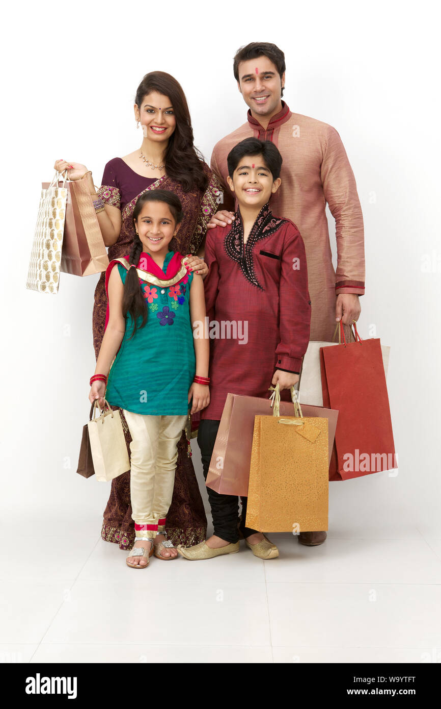 Family carrying shopping bags and smiling Stock Photo - Alamy