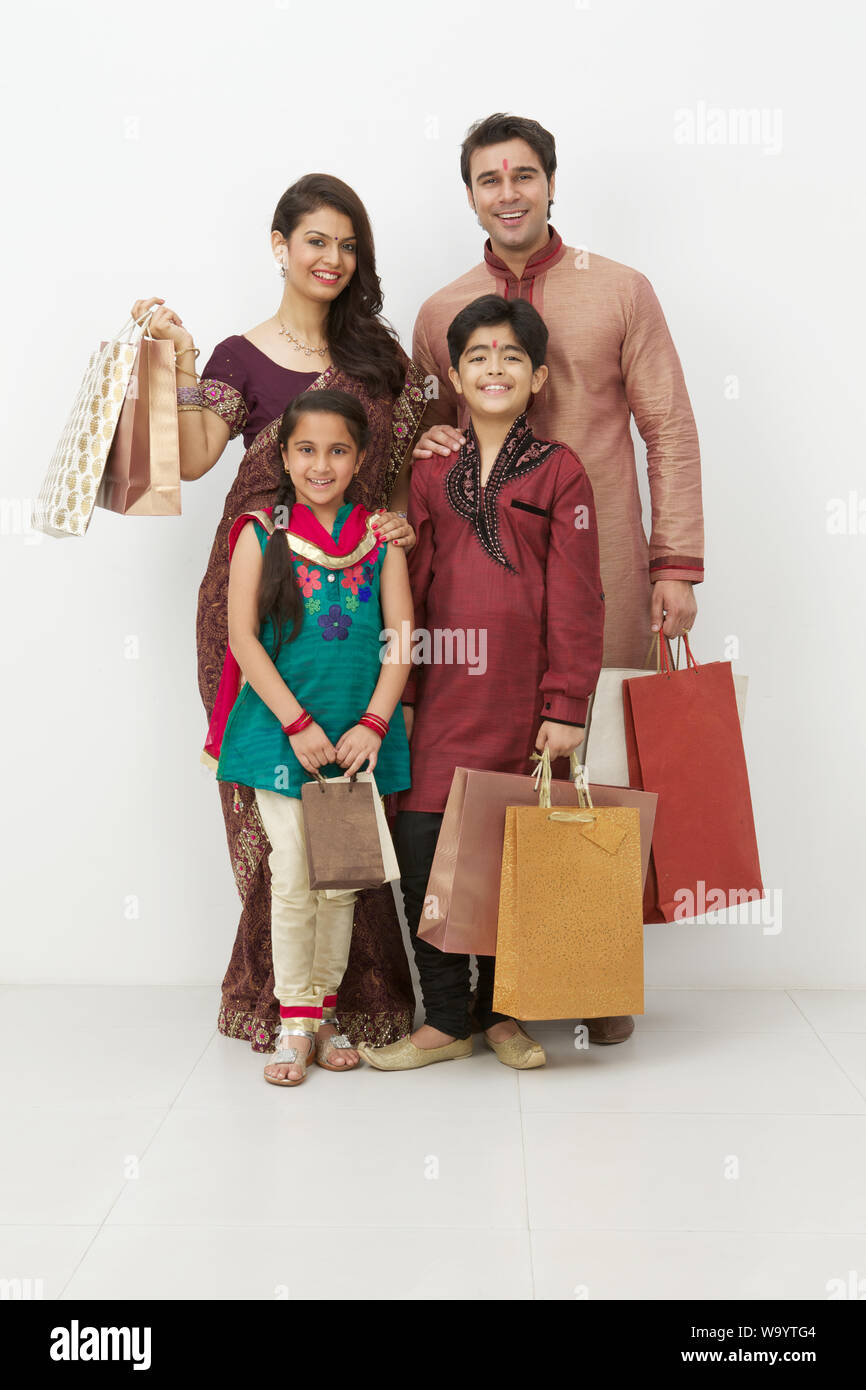 Family carrying shopping bags and smiling Stock Photo - Alamy