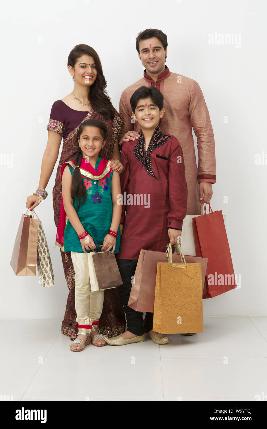 Family carrying shopping bags and smiling Stock Photo - Alamy