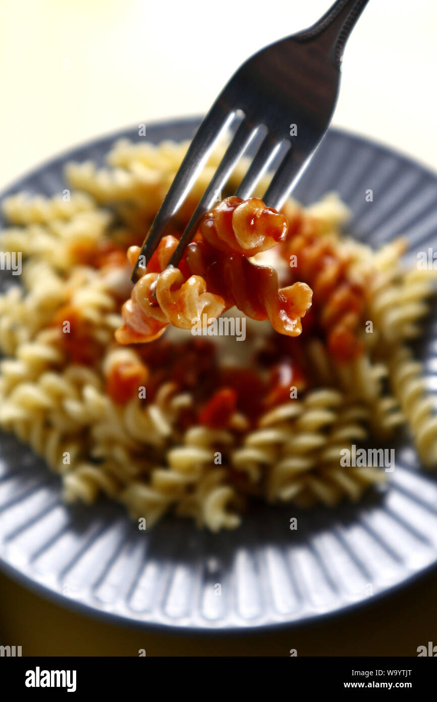 Photo of freshly cooked spiral pasta with cheese and tomato sauce Stock ...