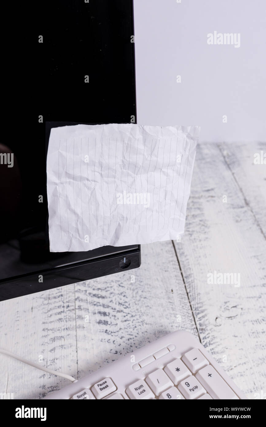 Notation paper taped to black computer monitor screen near white ...