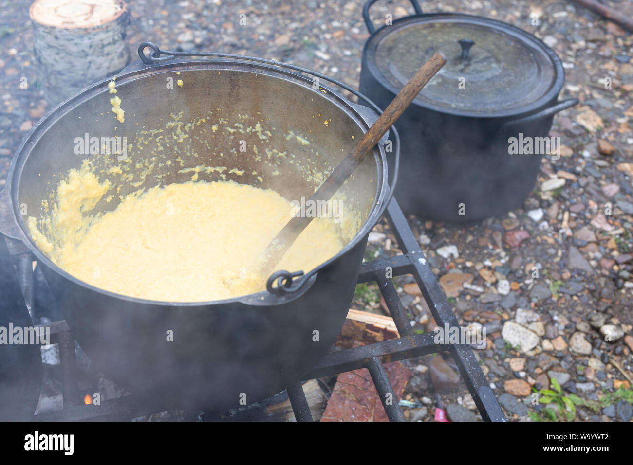 Corn porridge is cooked in a pot at the stake. camping kitchen ...