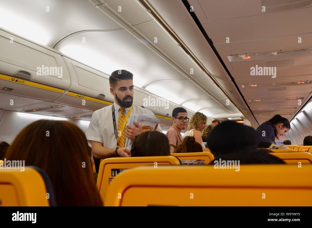 interior of a ryanair flight with cabin crew handing out inflight ...