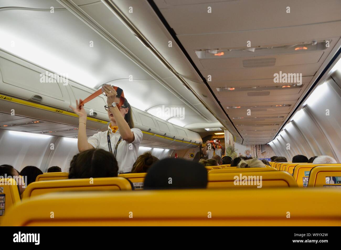 interior of a ryanair flight with cabin crew giving safety ...