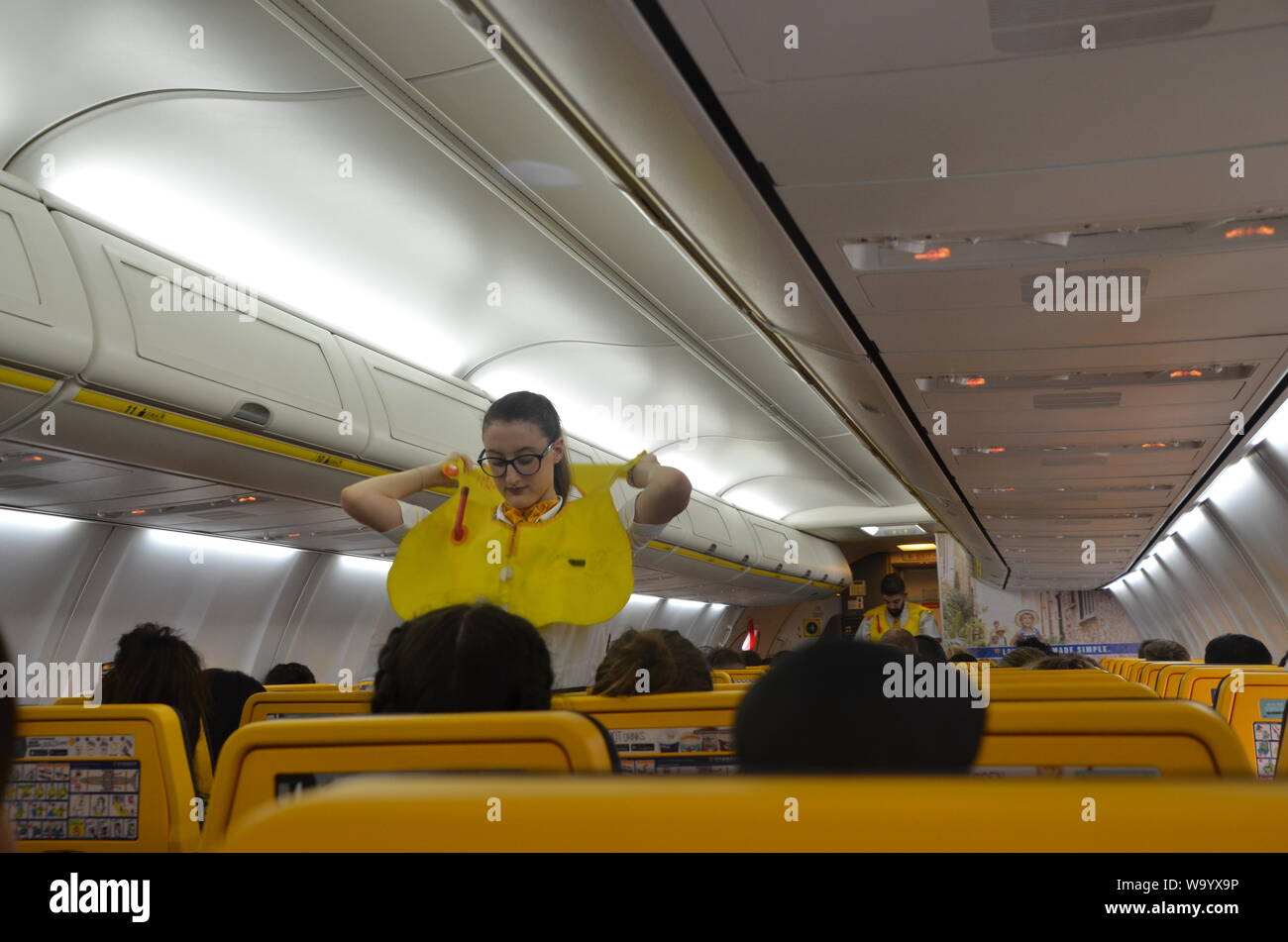 interior of a ryanair flight with cabin crew giving safety ...