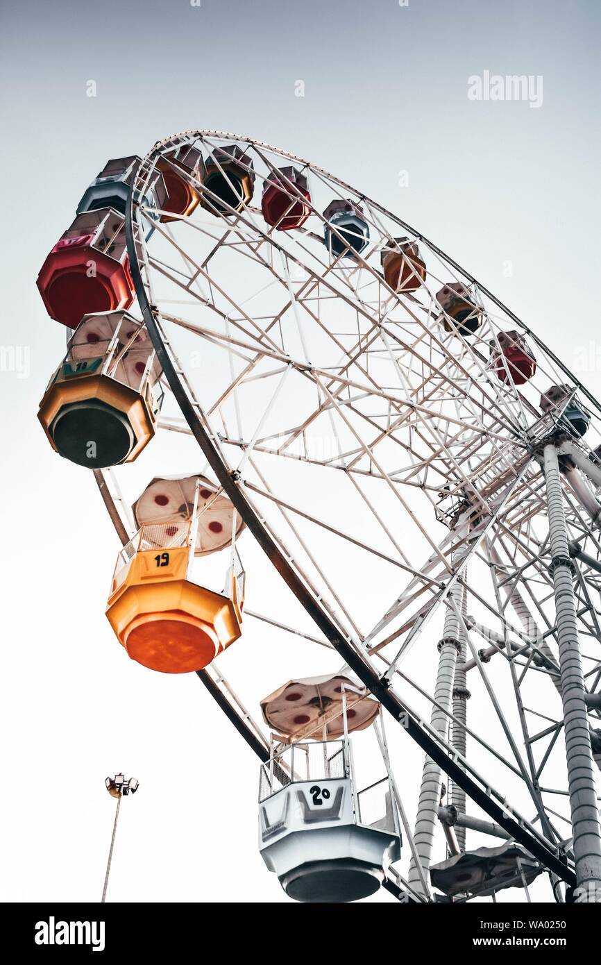 Vertical low angle shot of a tall Ferris wheel with the beautiful clear ...