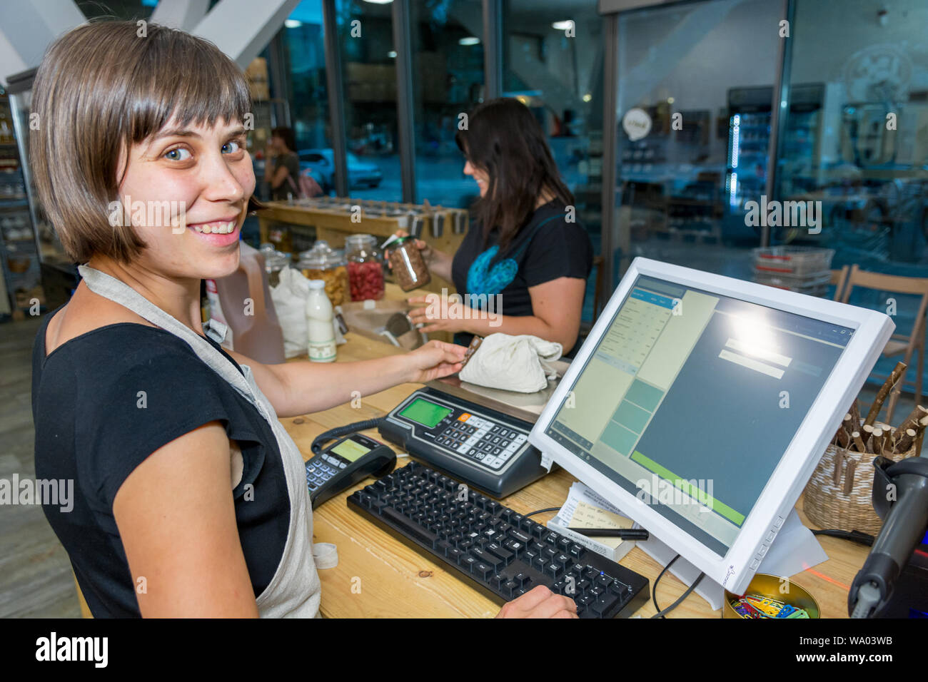 Female shop assistant serving a customer at a desk Stock Photo - Alamy