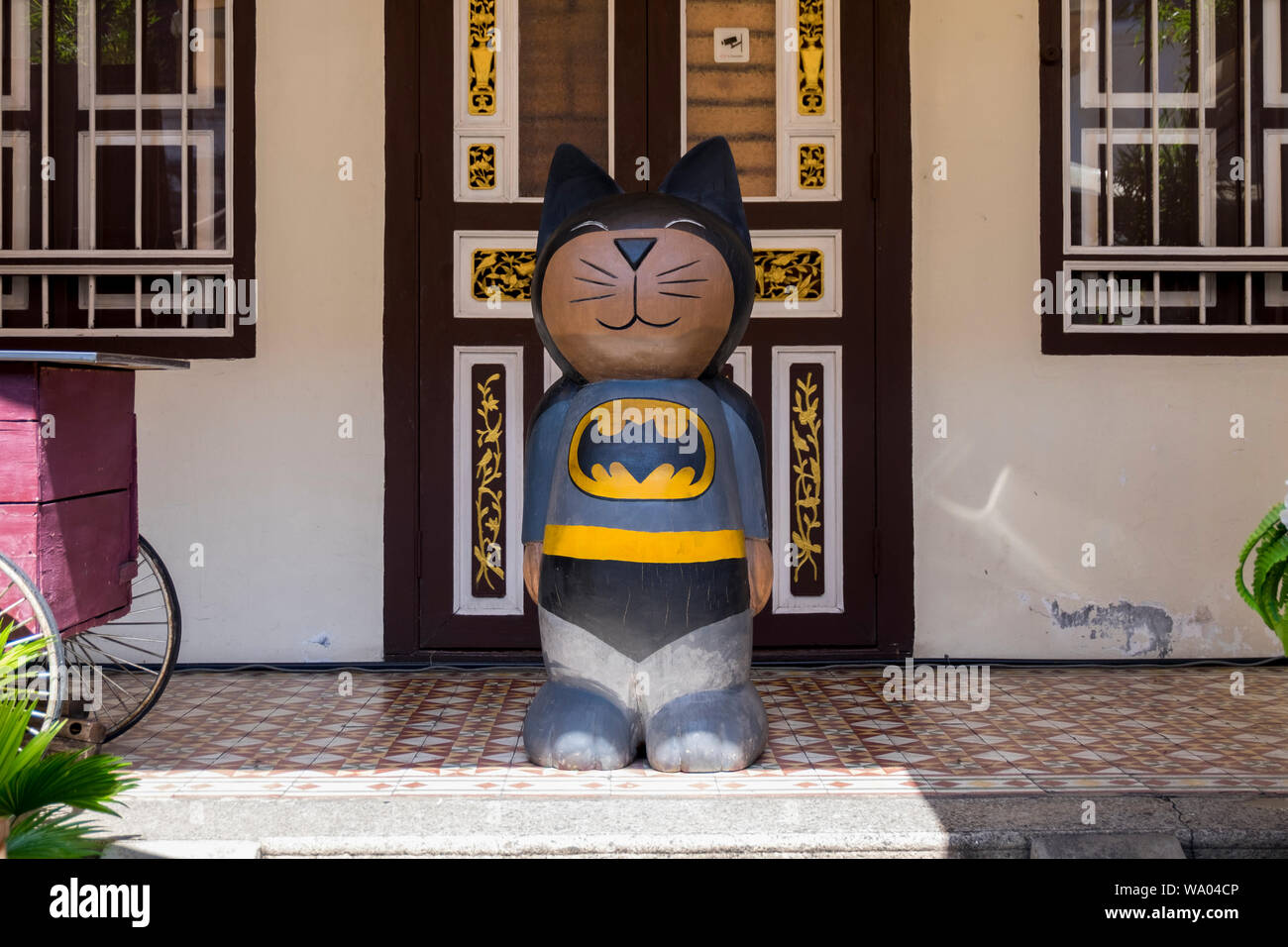 A funny cartoon cat Batman figure on a porch in George Town, Penang ...