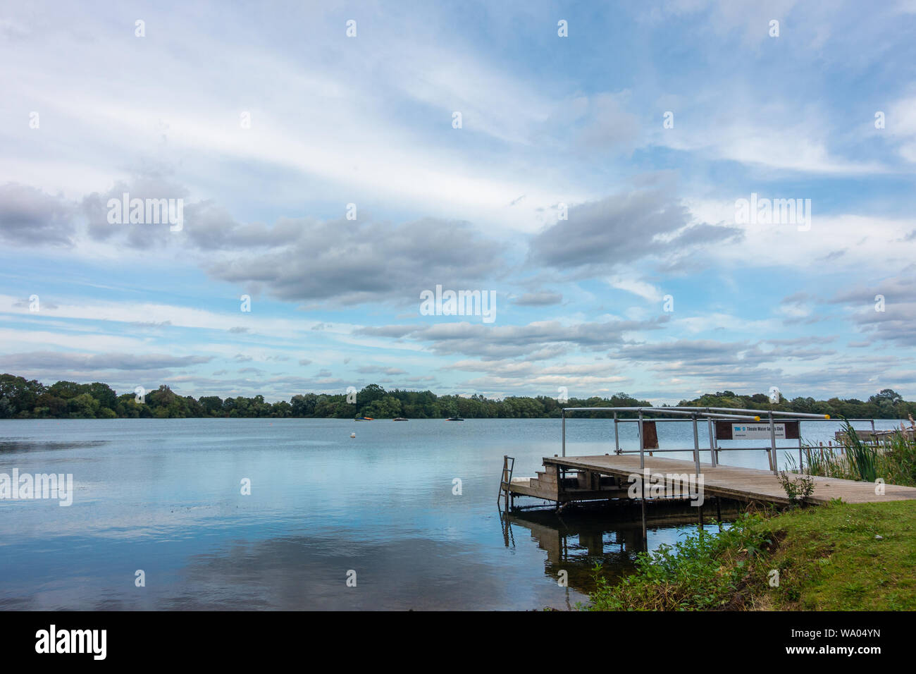 A view across a lake in Reading, UK. A calm scene with clouds reflected ...