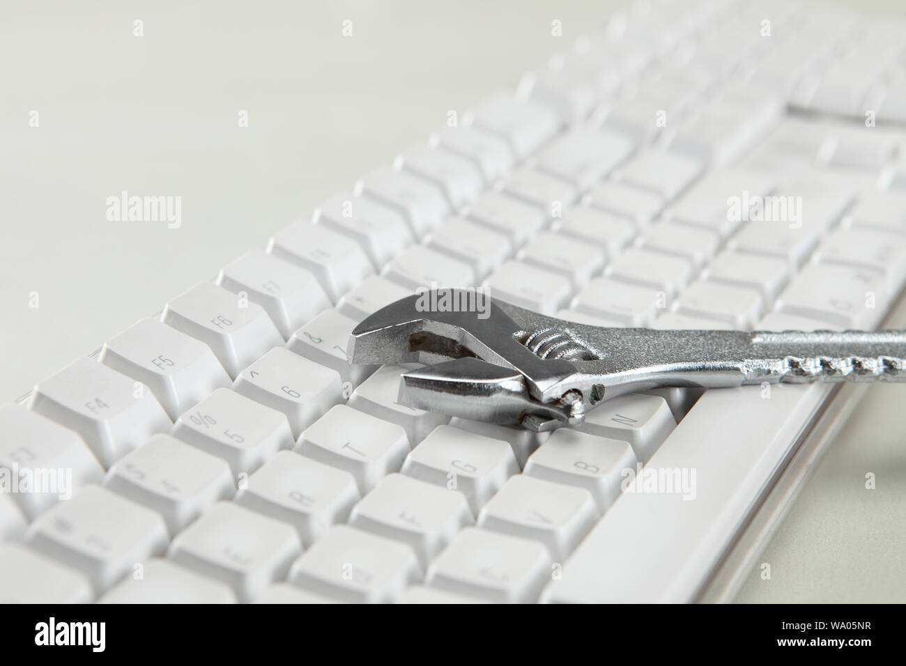 Wrench on a computer keyboard Stock Photo - Alamy