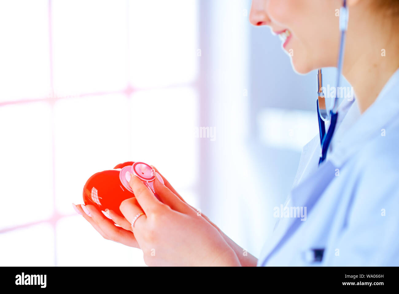 Doctor in a hospital examines a heart with a stethoscope. Workplace ...