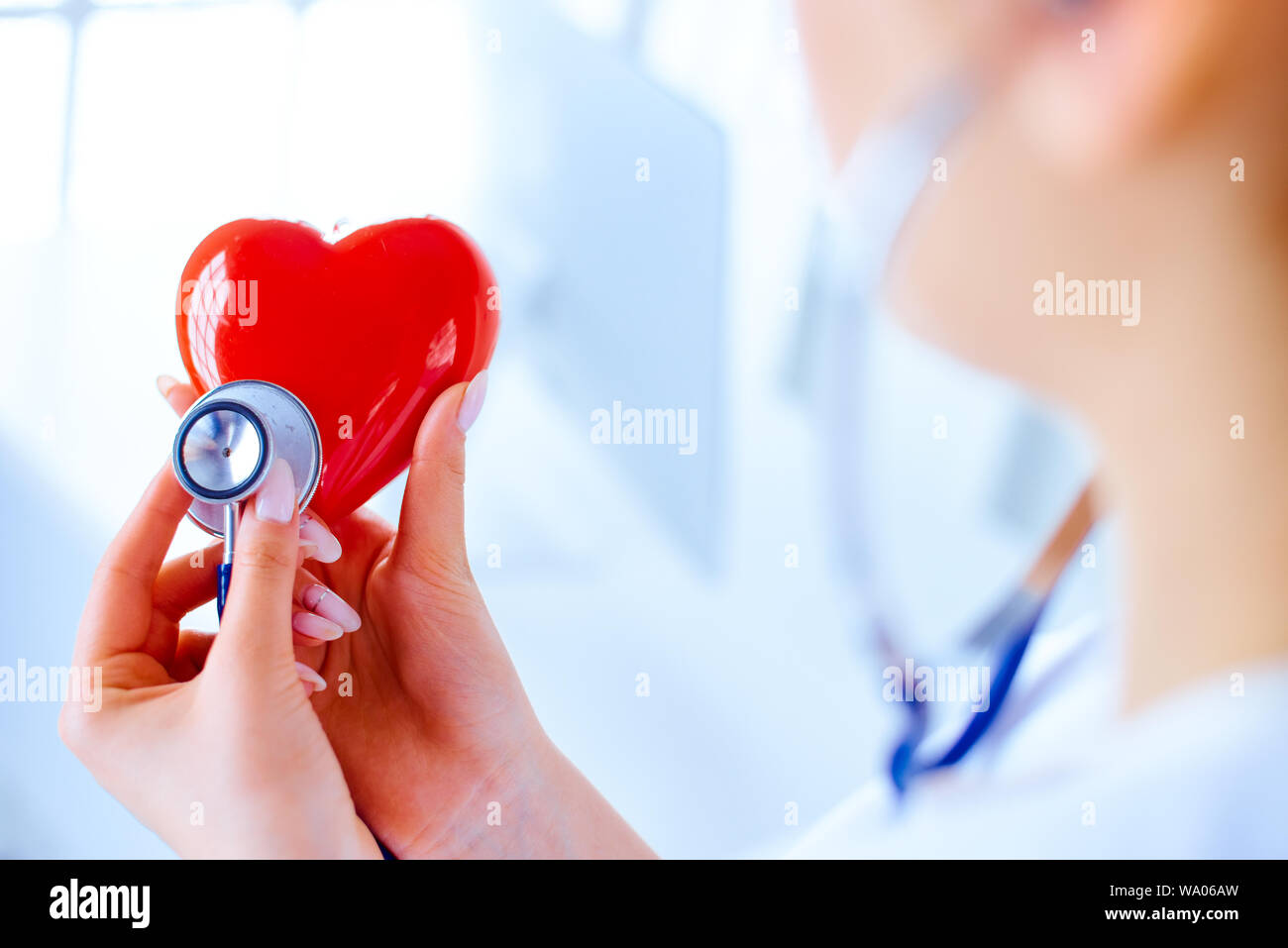 Doctor with a stethoscope examines the heart. Young doctor cardiologist ...