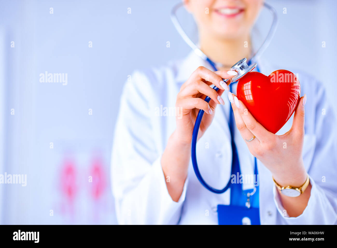 Female doctor with stethoscope examining red heart. Health, medicine ...