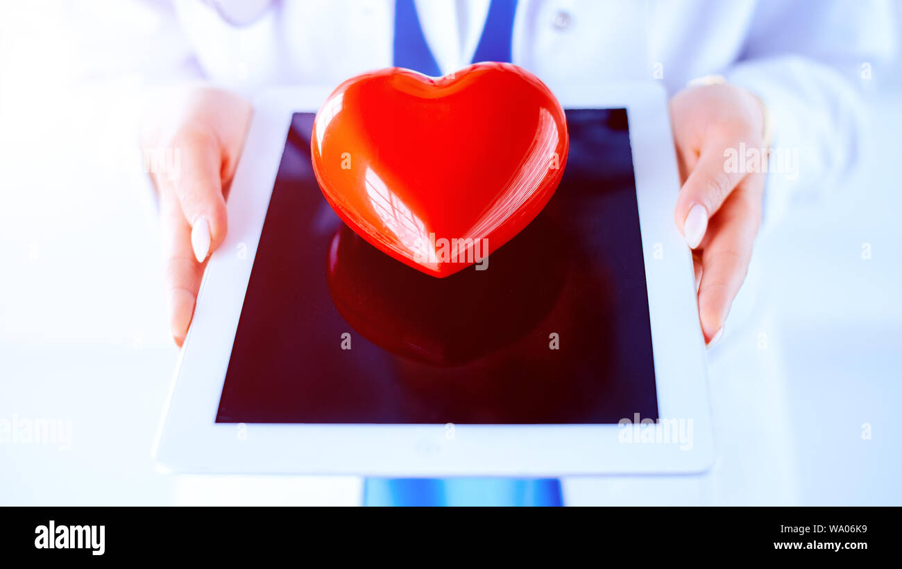 Doctor cardiologist with stethoscope using digital tablet and holding ...