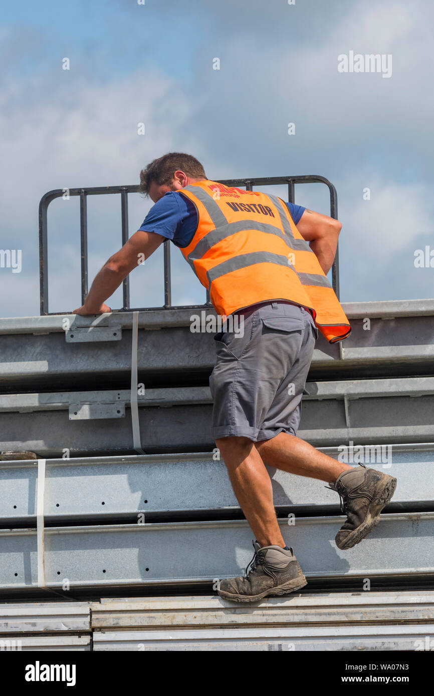 a workman working at height wearing an high visibility vest without any ...
