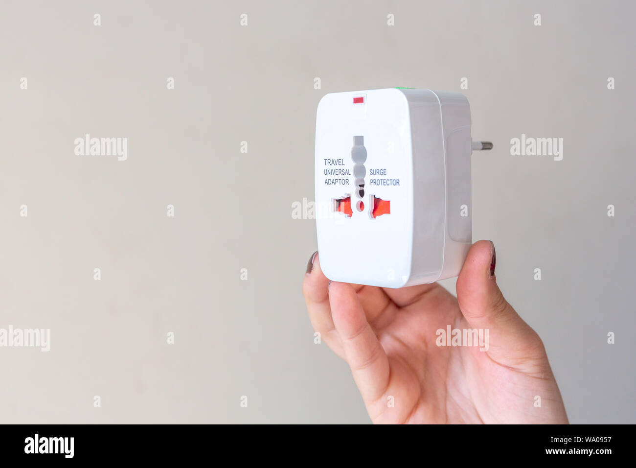 Close up of woman hand holding universal electric socket plug adapters ...