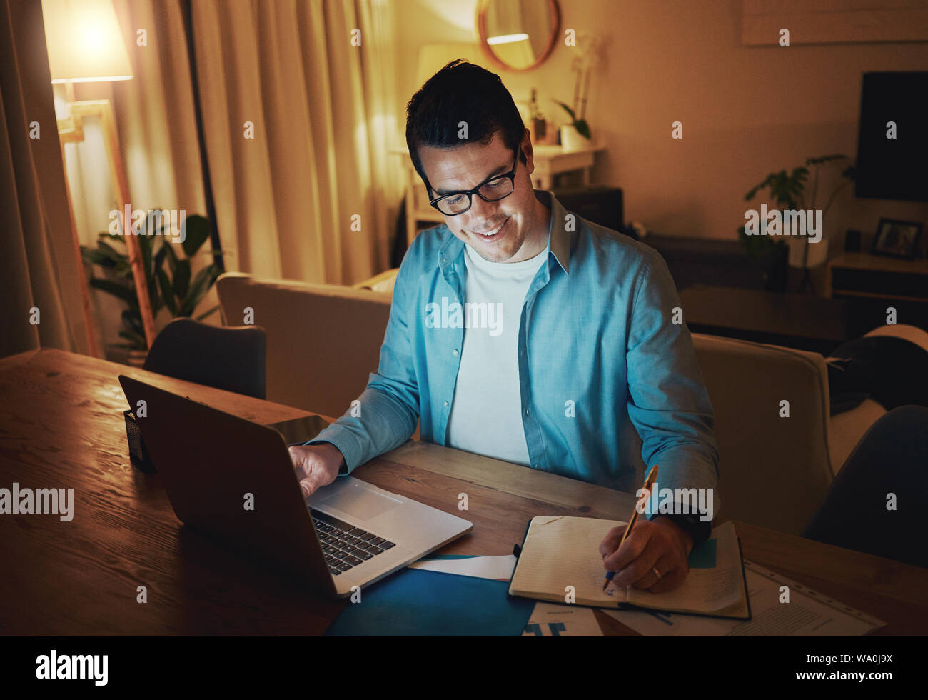 Happy man working alone with an open laptop on a desk at home Stock ...