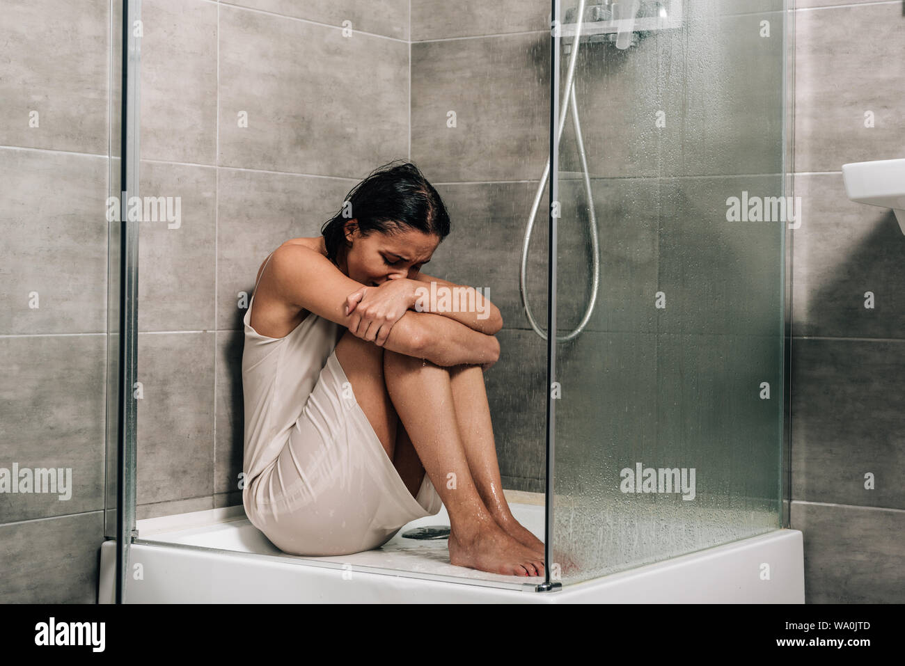 lonely worried woman sitting in shower at home Stock Photo Alamy
