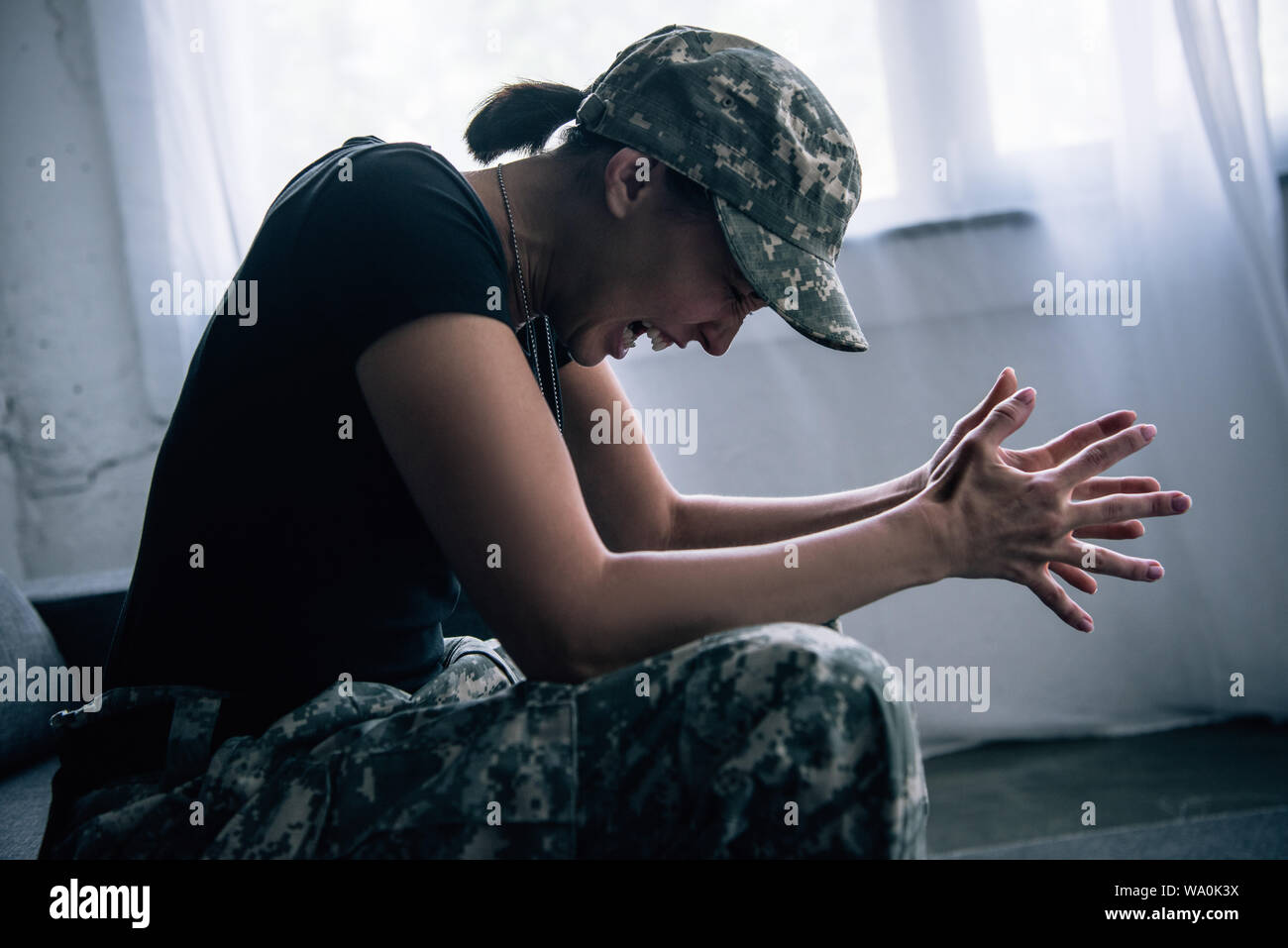 depressed woman in military uniform screaming at home Stock Photo - Alamy