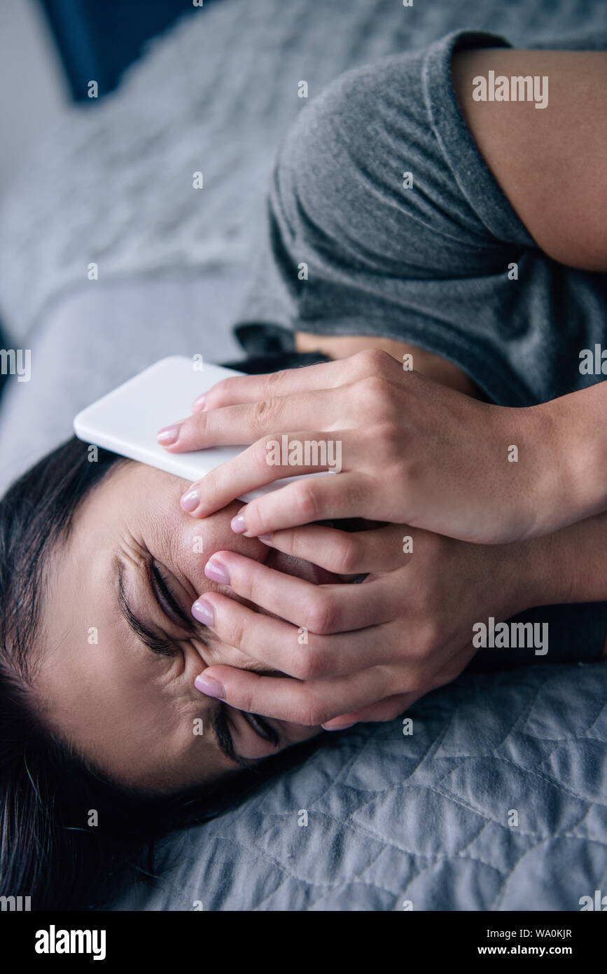 lonely depressed woman on bed talking on smartphone and crying in ...