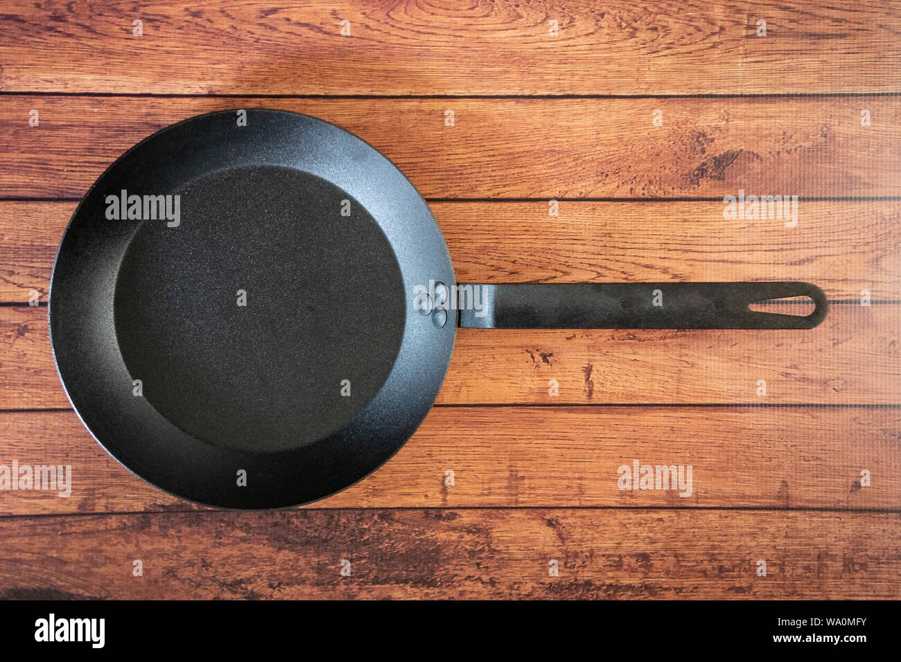 Isolate carbon steel skillet pan on a wooden background - overhead top ...
