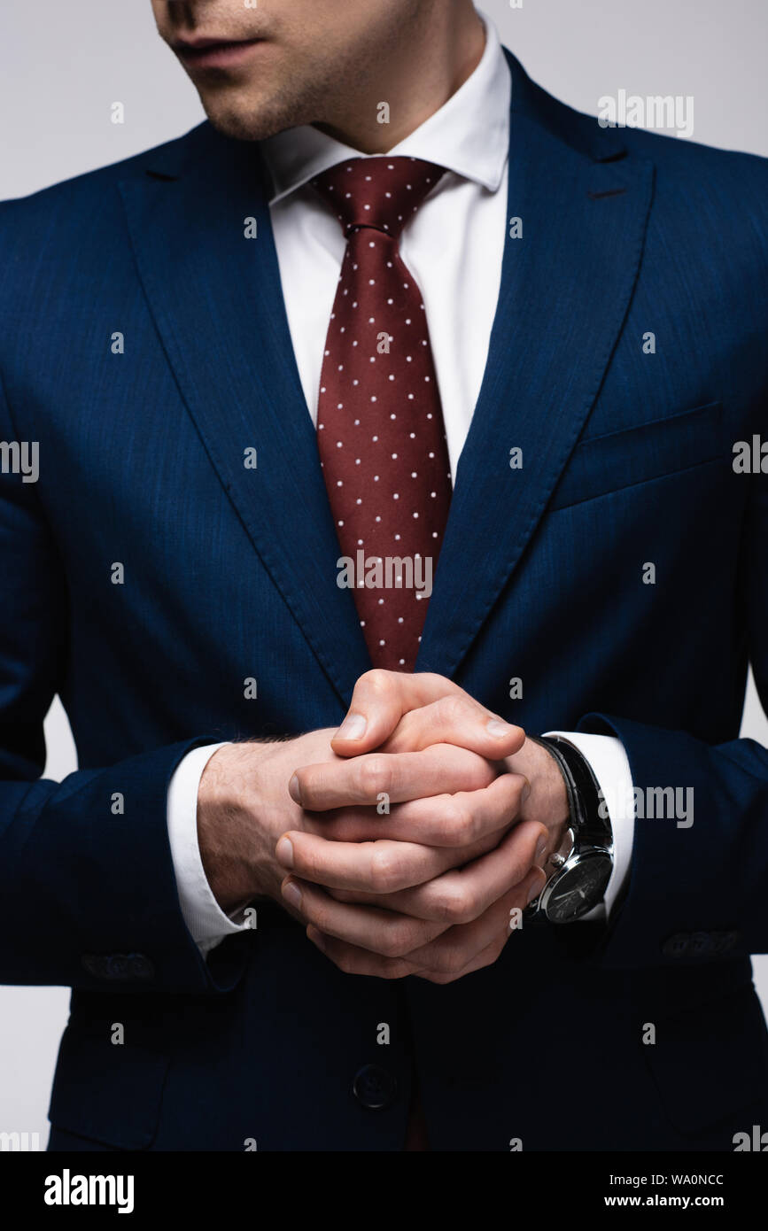 partial view of confident businessman standing with clenched hands ...